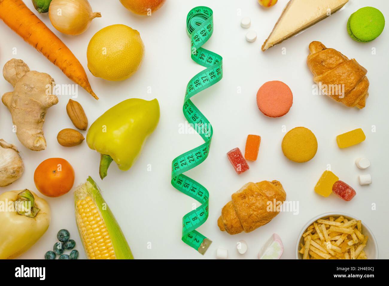 Various useful and unhealthy food items with measuring tape on white ...