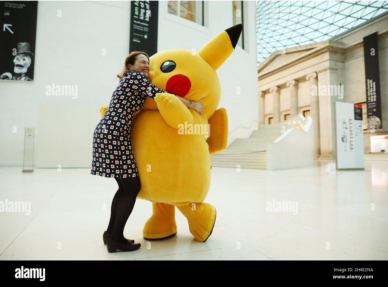 A woman greets a life-size Pokemon character Pikachu pictured during ...