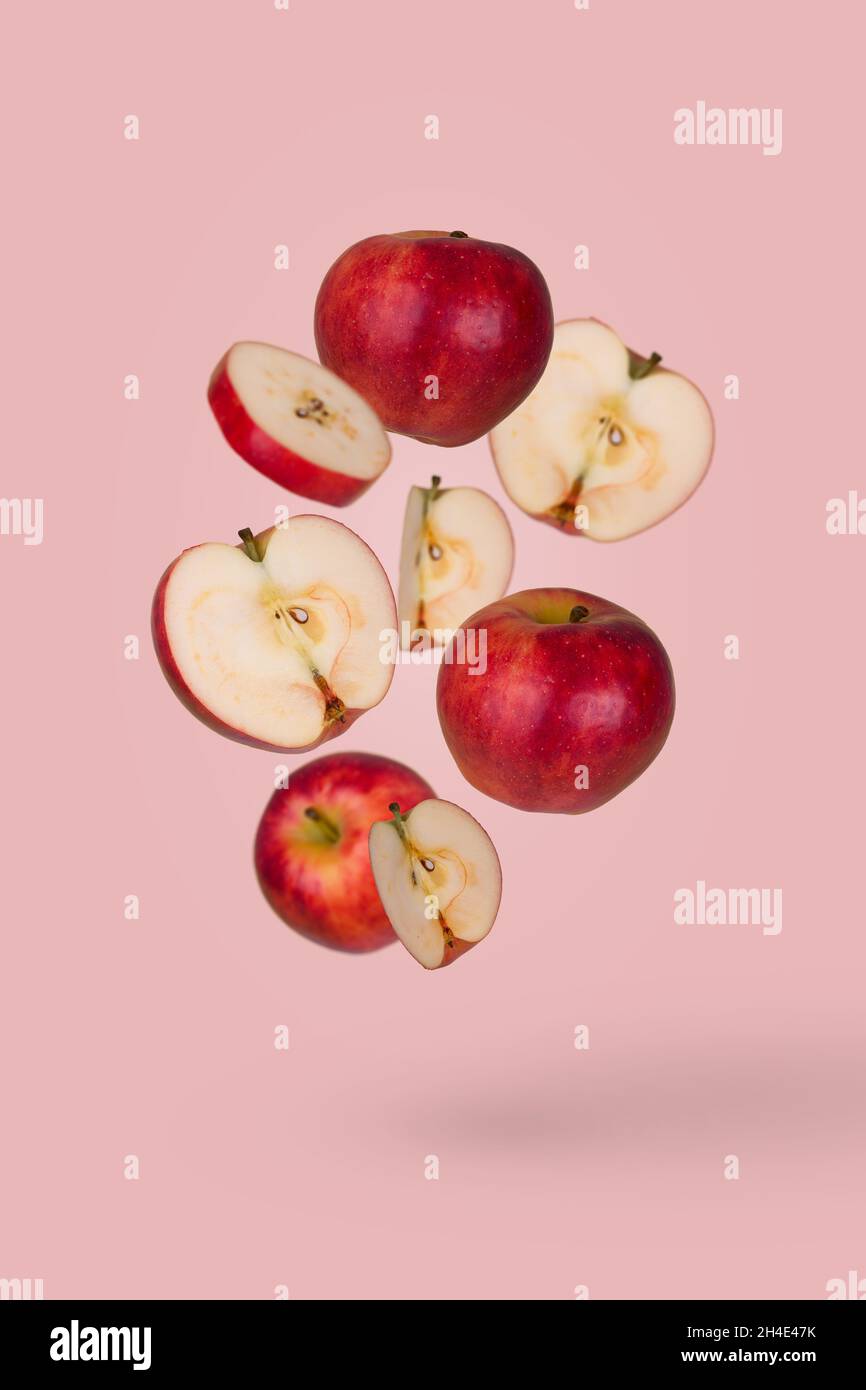 Fresh sliced and whole apple floating in the air isolated on pastel ...