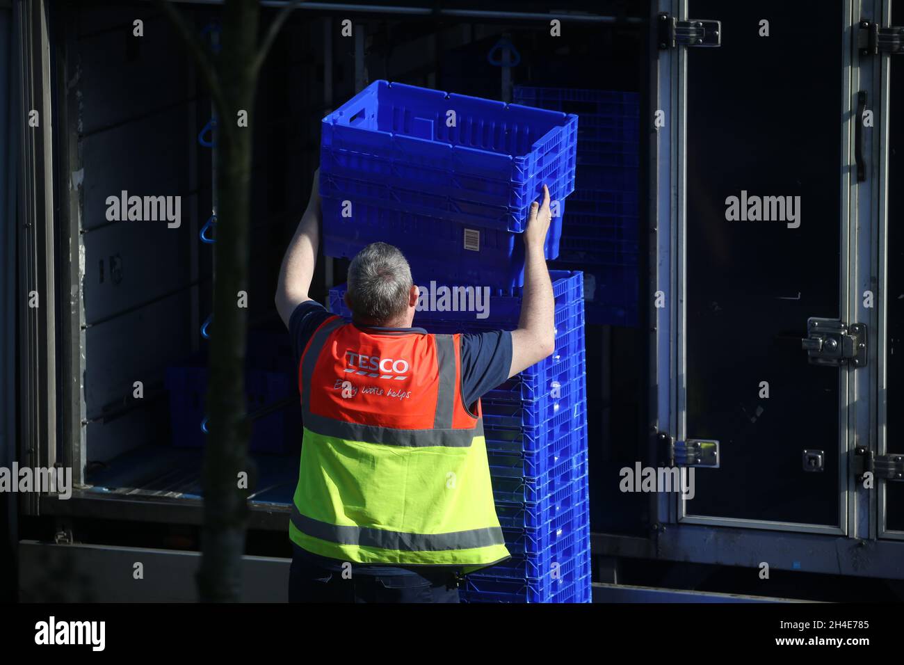 A Tesco home delivery man piles up some boxes back into a van in London ...