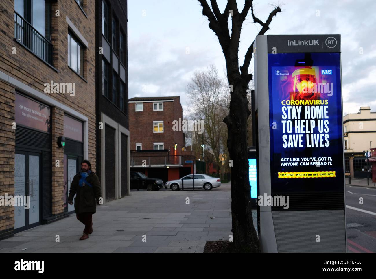 A pedestrian walks past signage about coronavirus in north London Stock ...