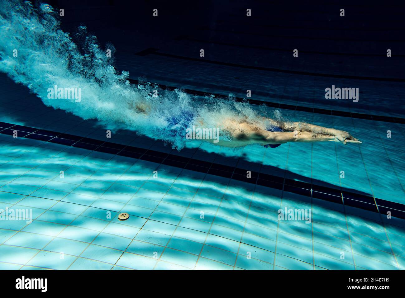 Underwater camera work. One male swimmer training at pool, indoors ...