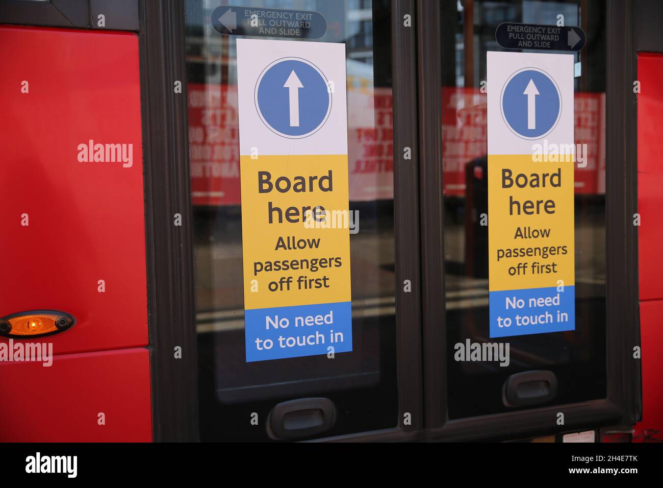 Signs on a London bus point to access through the middle-door as part ...