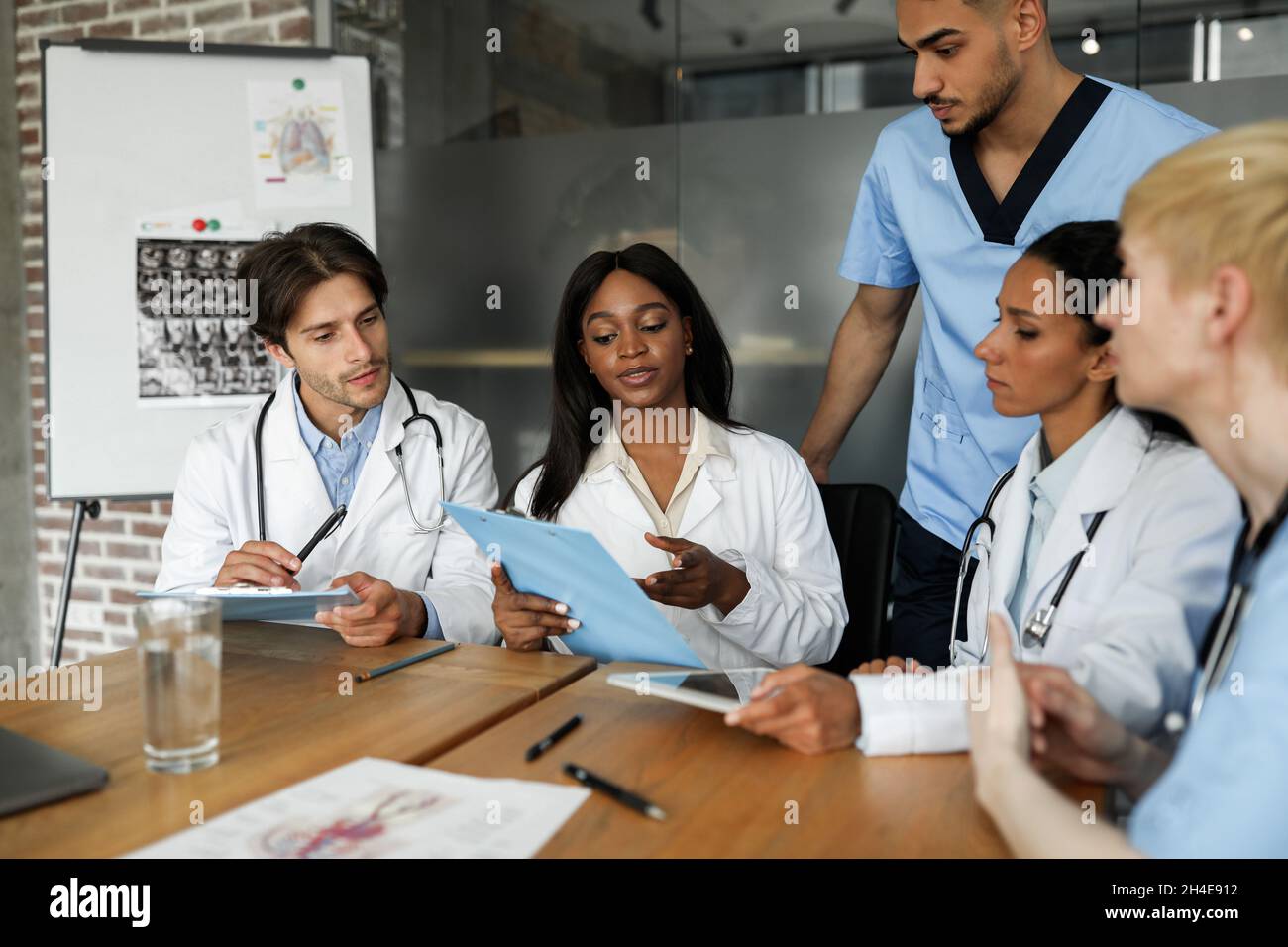Health workers having team-building, listening to head chief physician ...