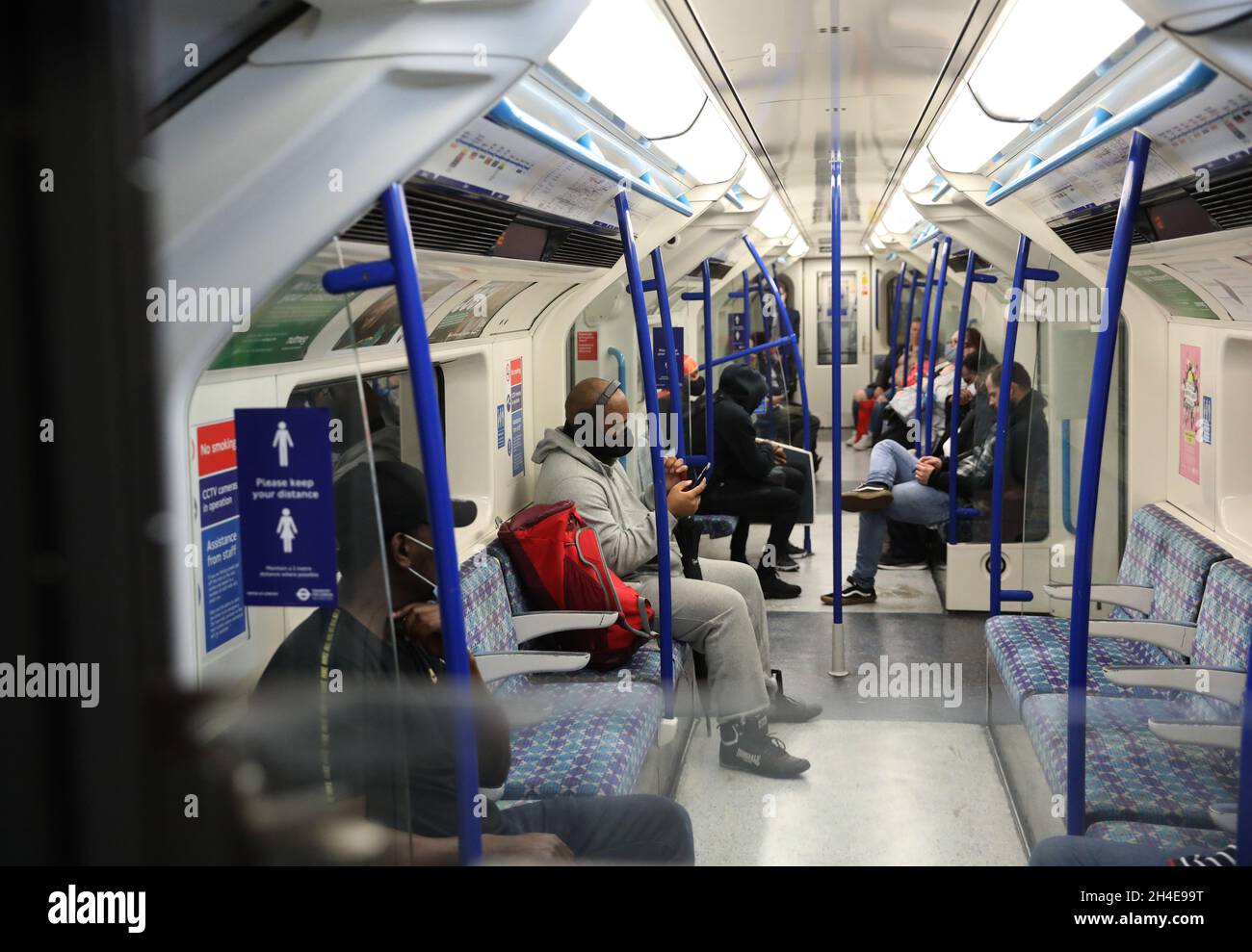 Commuters wearing a protective face mask while traveling on a ...