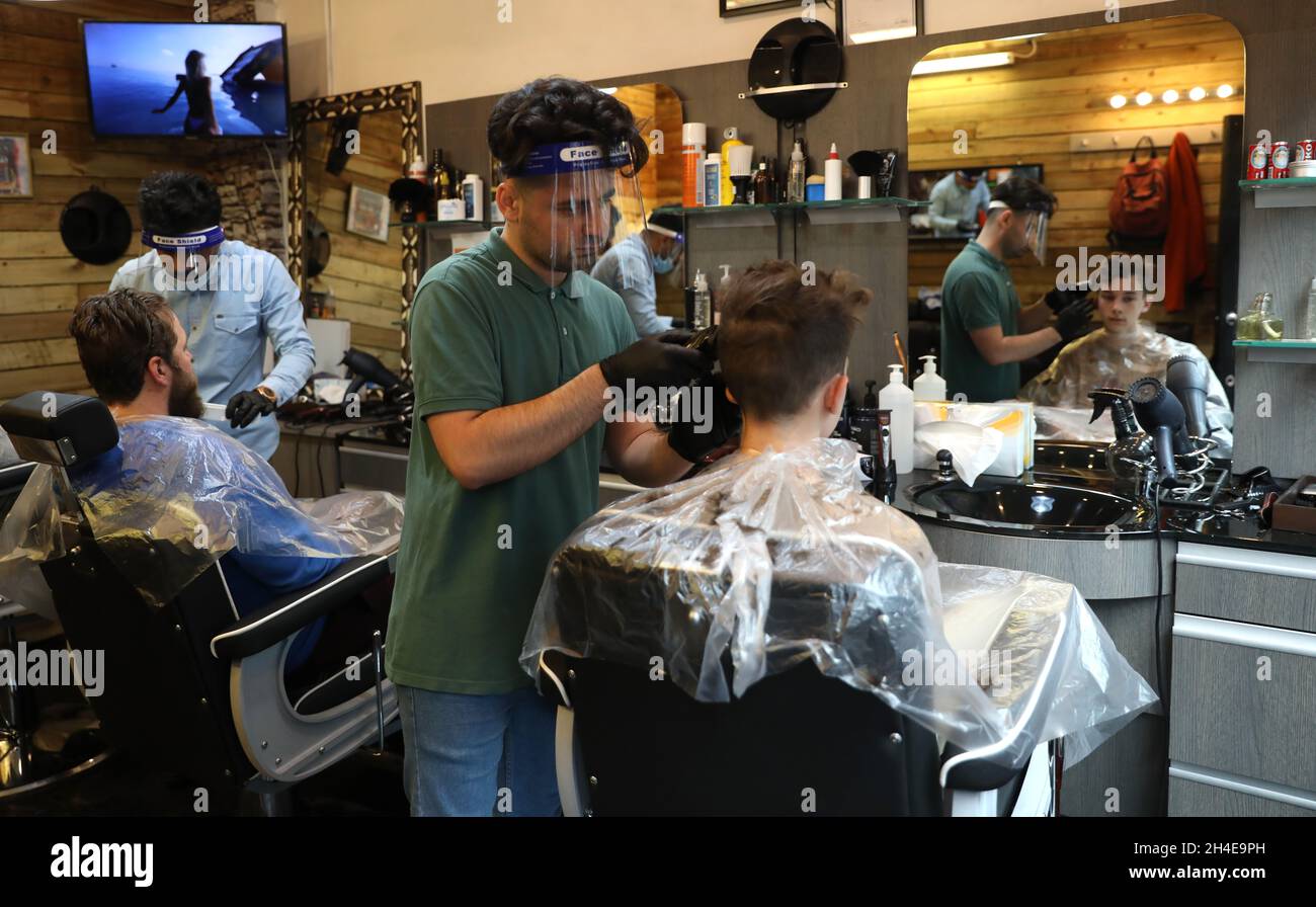 ,Barbers wearing Personal Protective Equipment (PPE) at work at a ...