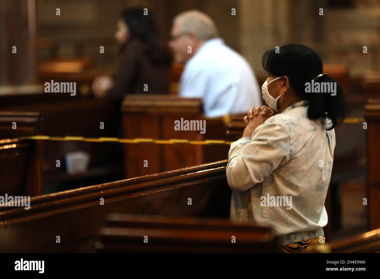 A churchgoer prays observing social distancing measures during a Sunday ...