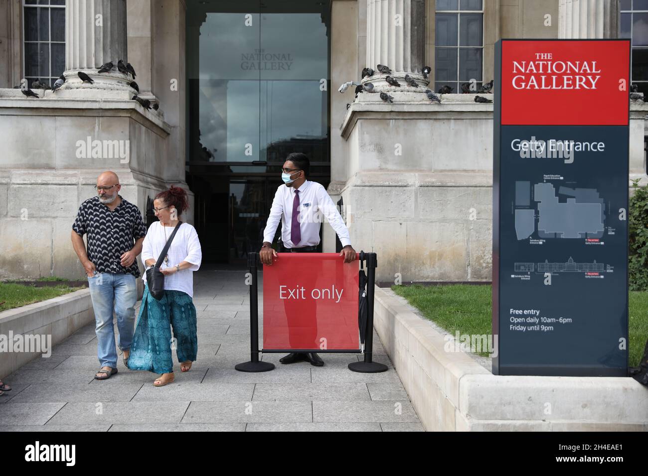 Staff and tourists wearing face covering outside the entrance of the ...