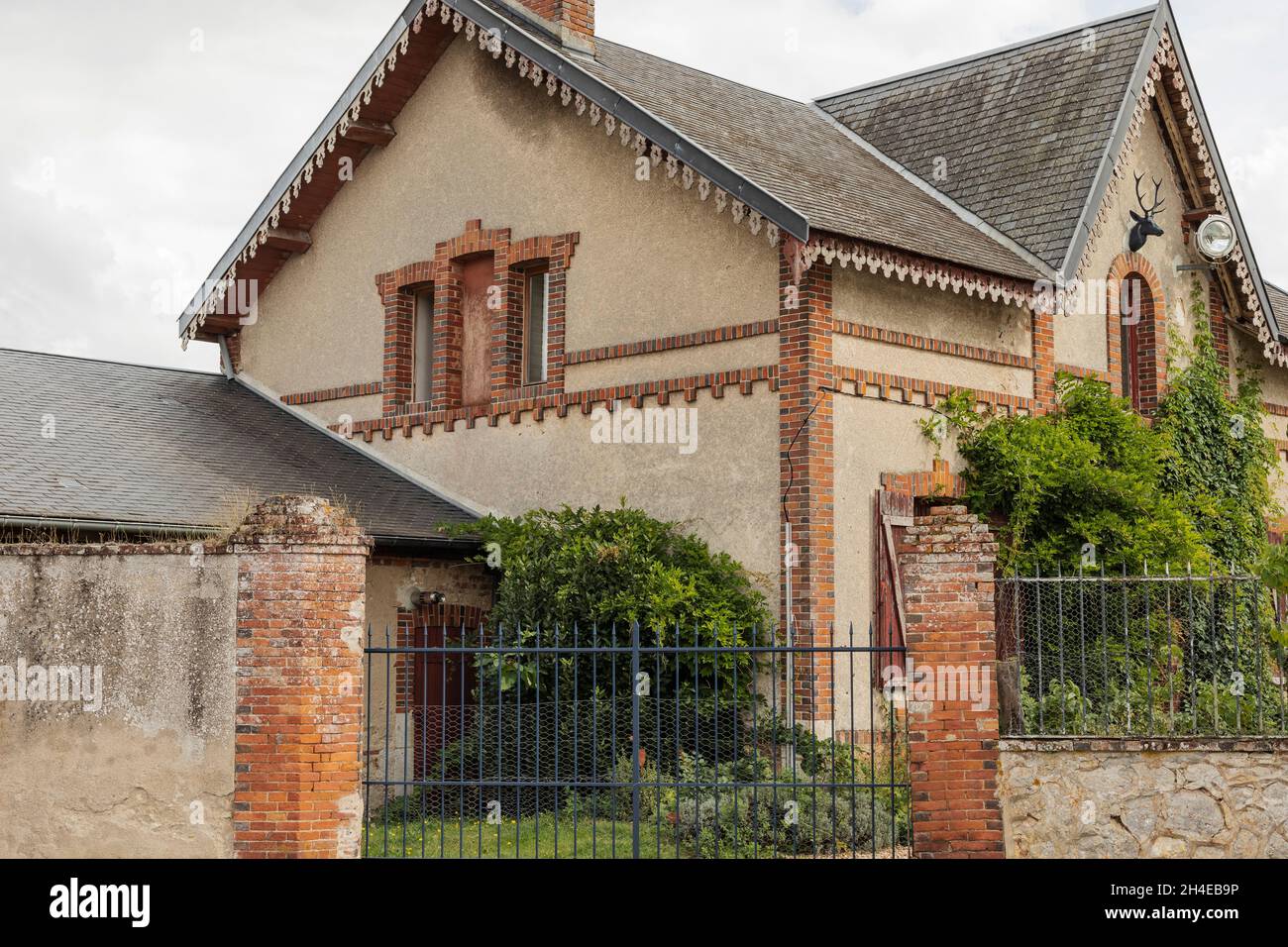 House behind a gate with deer head above a window Stock Photo - Alamy