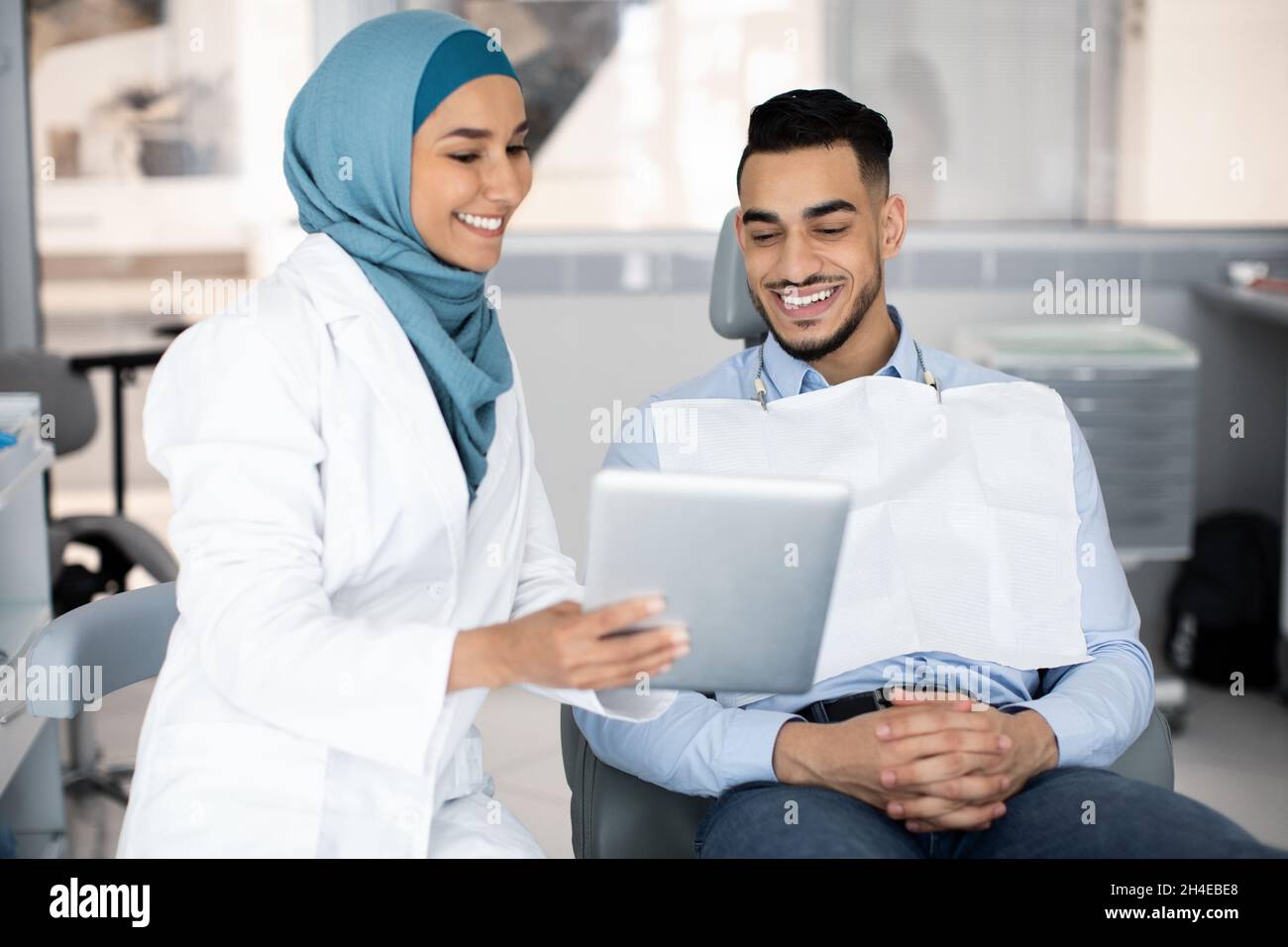 Muslim Dentist Lady Holding Digital Tablet, Showing Treatment Plan To ...