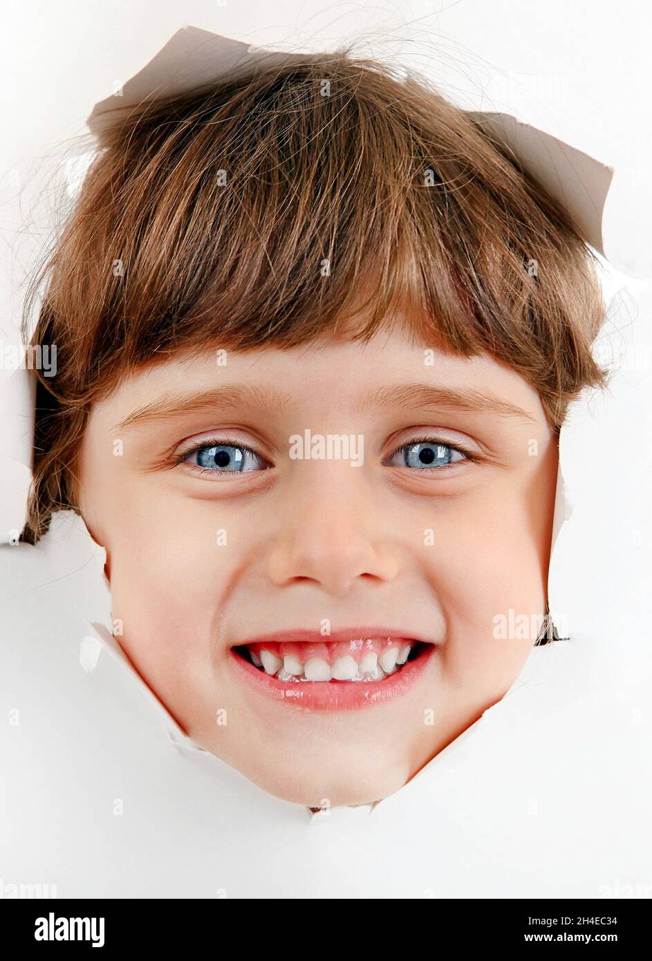 Cheerful Little Girl Face through the Hole Stock Photo - Alamy