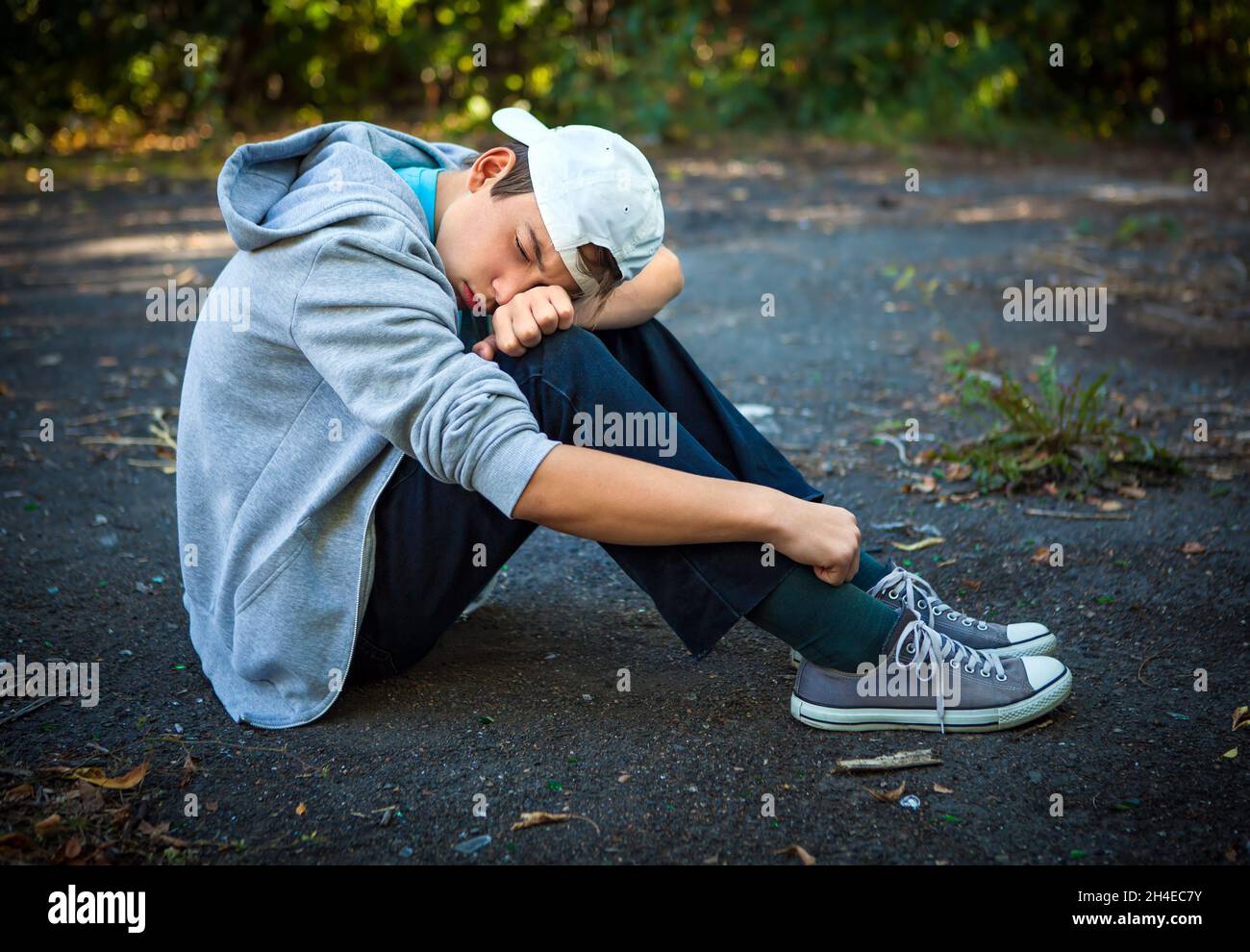 Sad Teenager sit on the Ground outdoor Stock Photo - Alamy