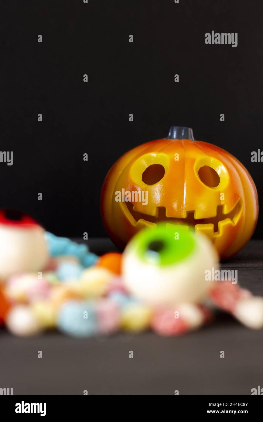 Colorful candies with a pumpkin on black background Stock Photo - Alamy