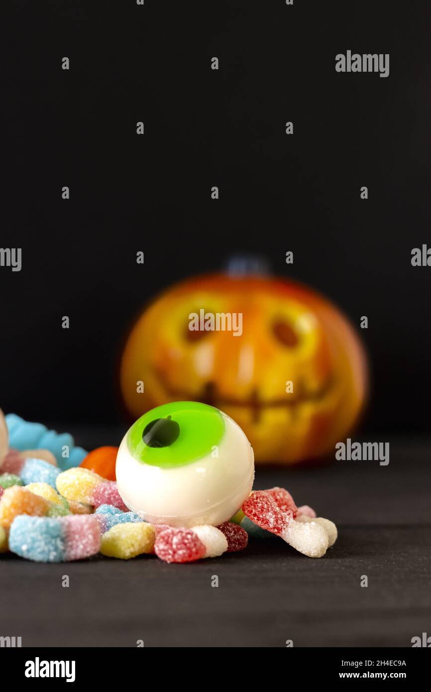 Colorful candies with a pumpkin on black background Stock Photo - Alamy