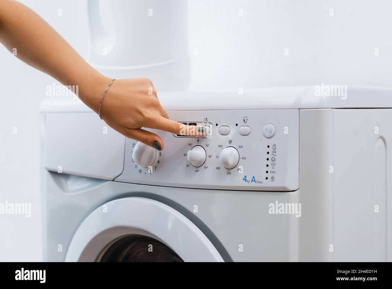 cropped view of housewife pushing button on washing machine Stock Photo ...