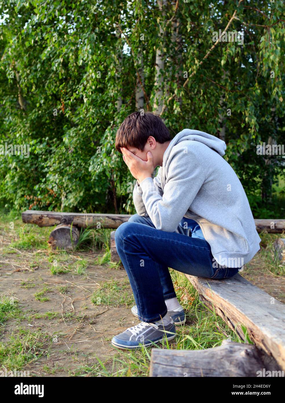 Sad Young Man sit on the Bench outdoor Stock Photo - Alamy