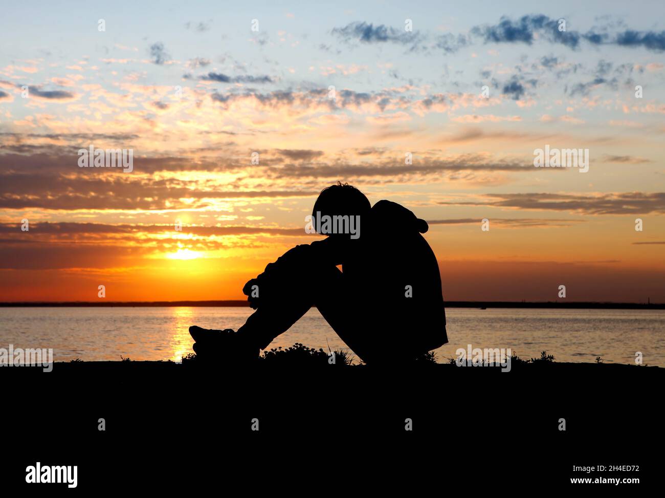 Sad Teenager Silhouette at the Sunset Background Stock Photo - Alamy