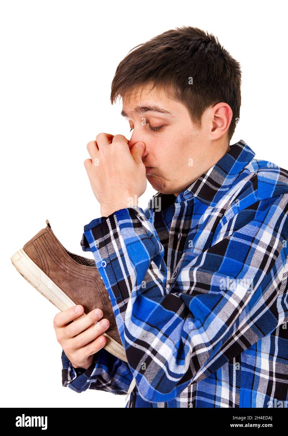 Young Man feel a stinking smell from a Sneaker on the White Background ...