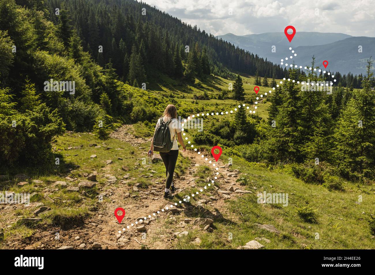 Woman traveler explorer with backpack hiking to the top of the mountain ...