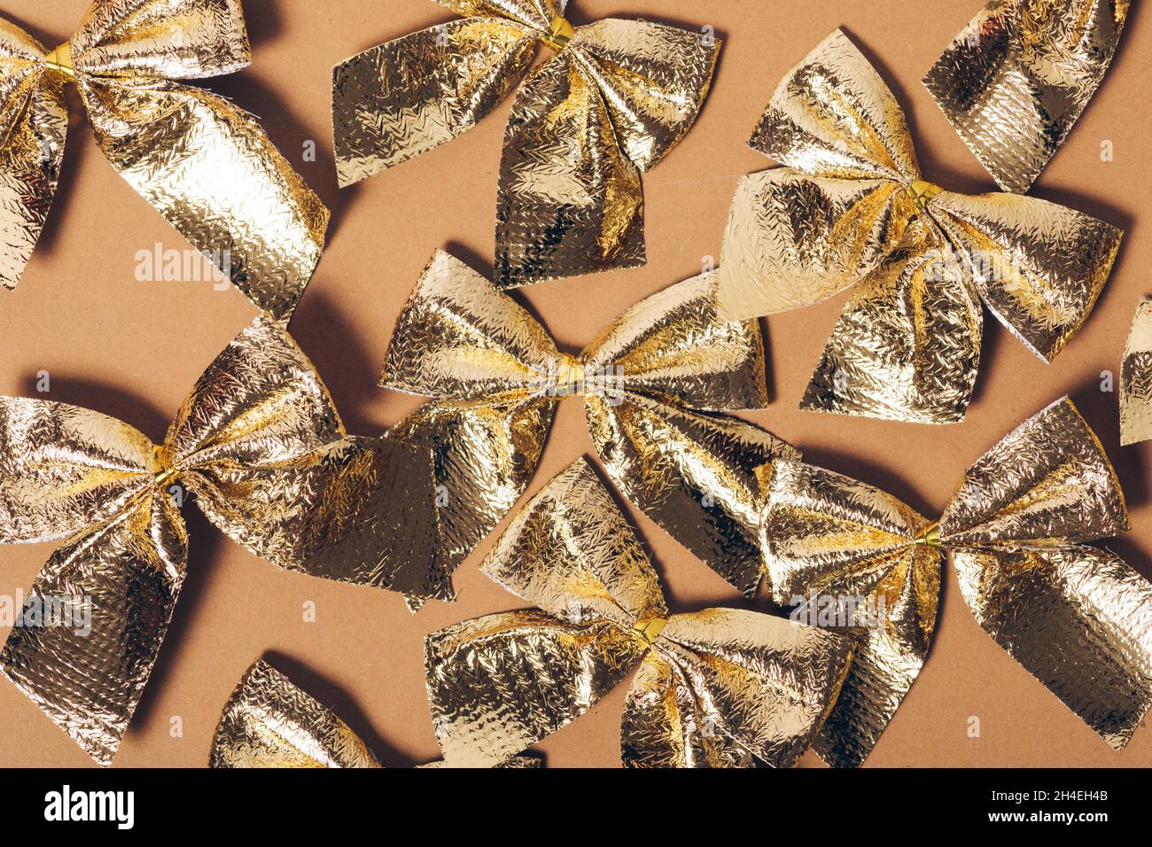 Festive vintage background of golden bows decorations on brown backdrop ...