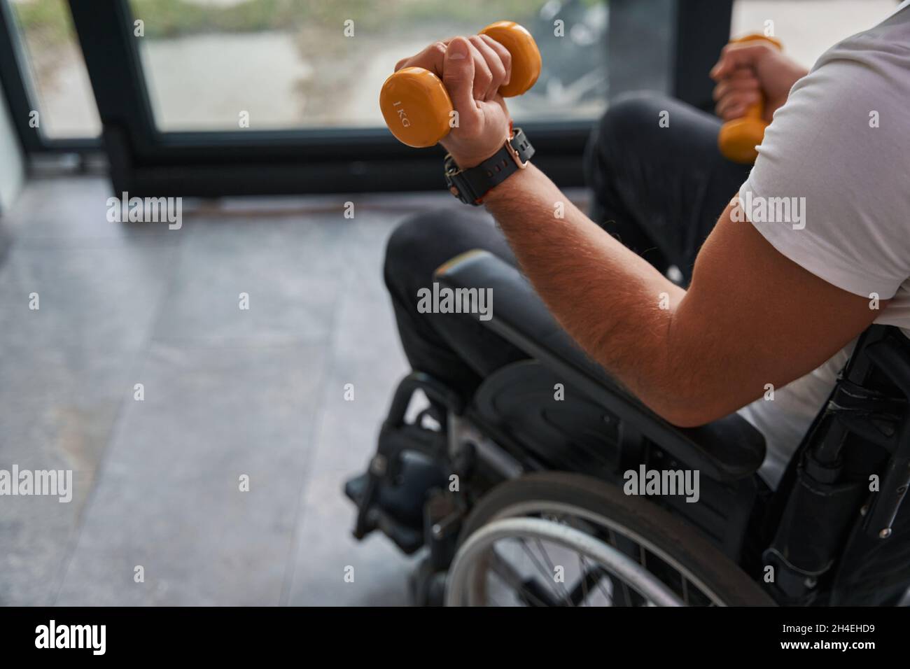 Man with physical disability using a wheelchair holding sports ...