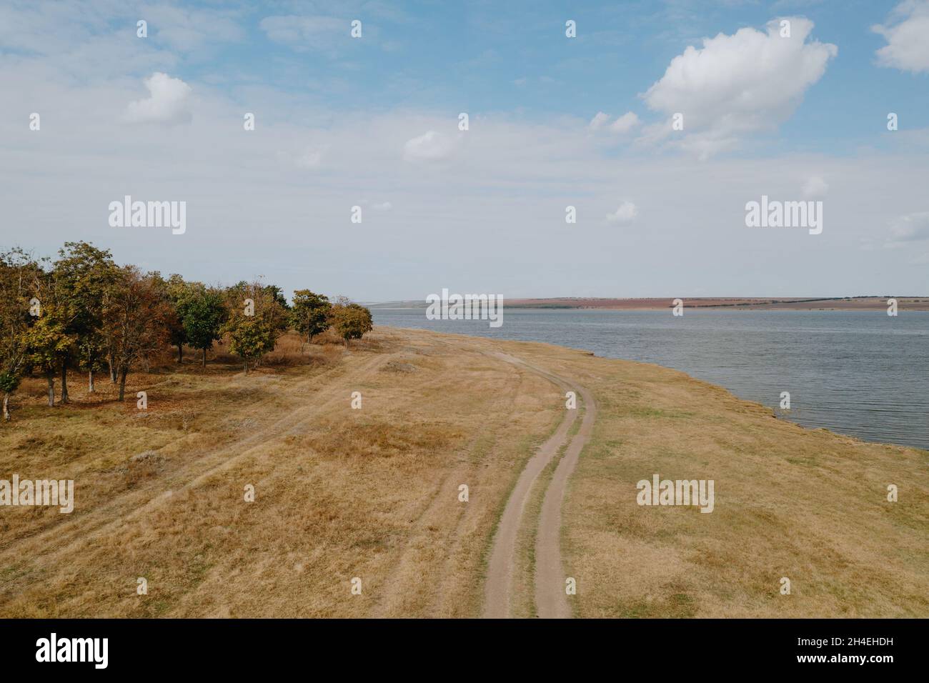 Countryside pathway going in an Autumnal landscape with trees, sky and ...