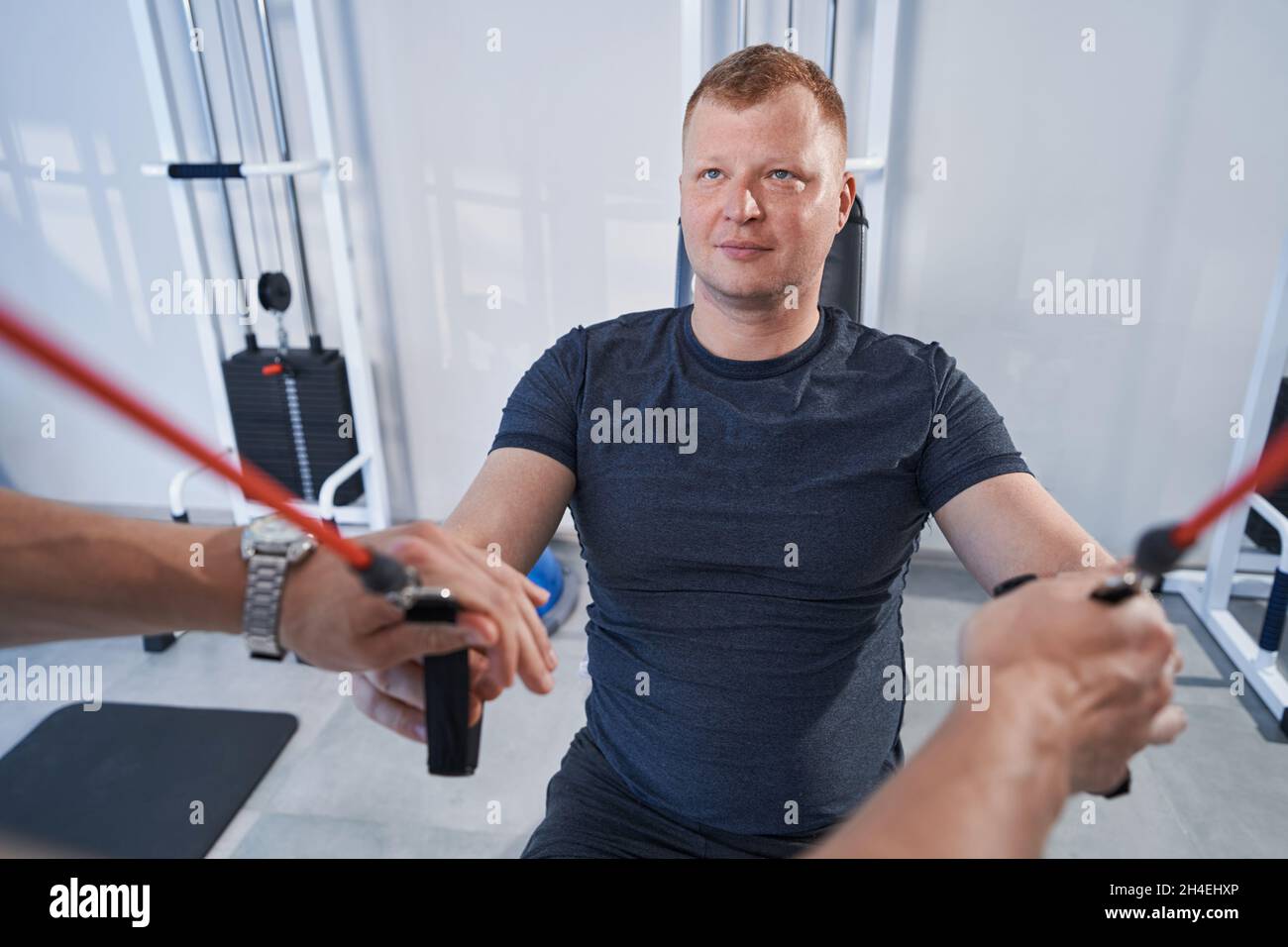 Man patient doing exercises of ligament sprain in physiotherapy clinic ...