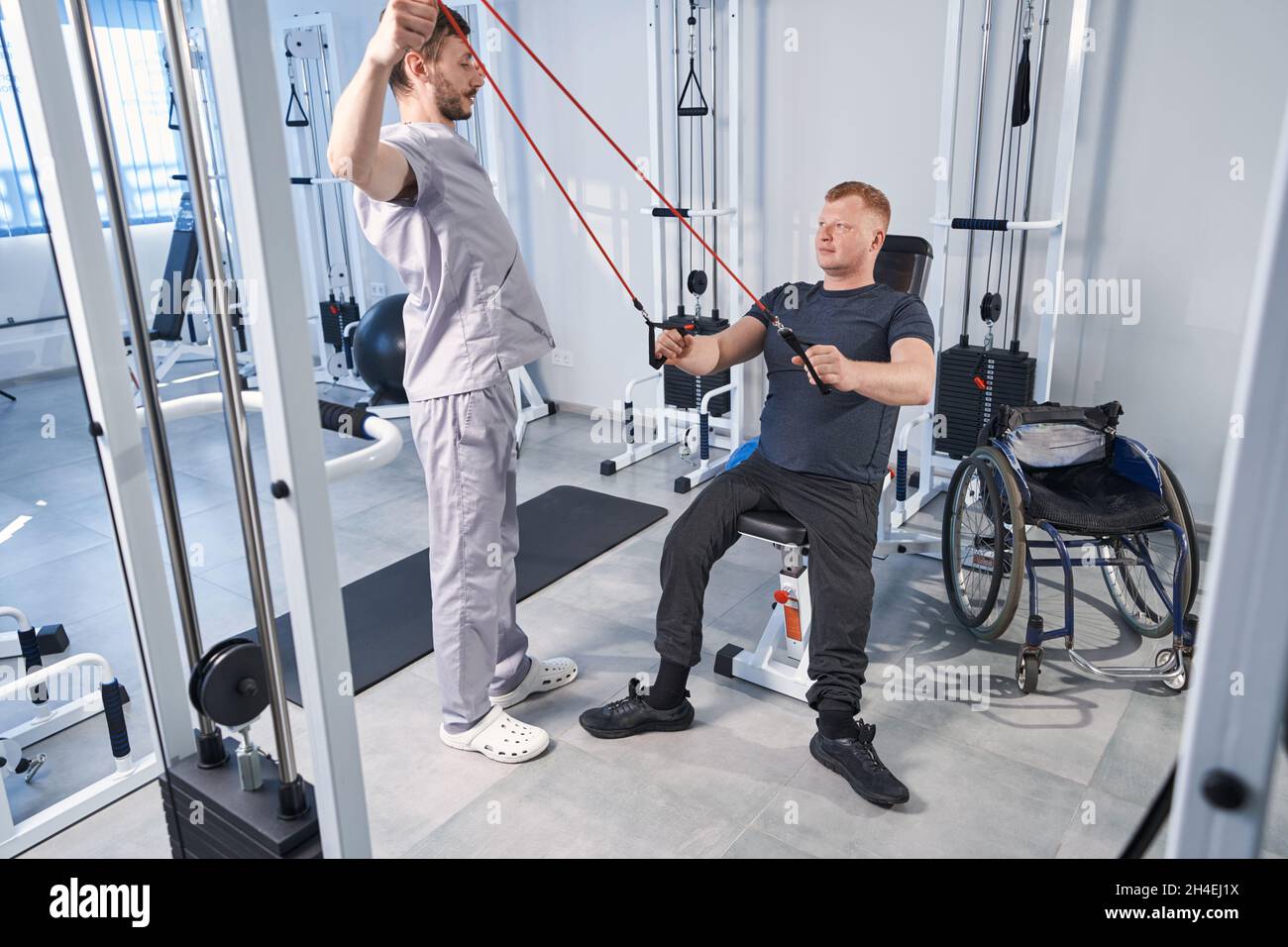 Man with disability do strength exercise for hand with physiotherapist ...