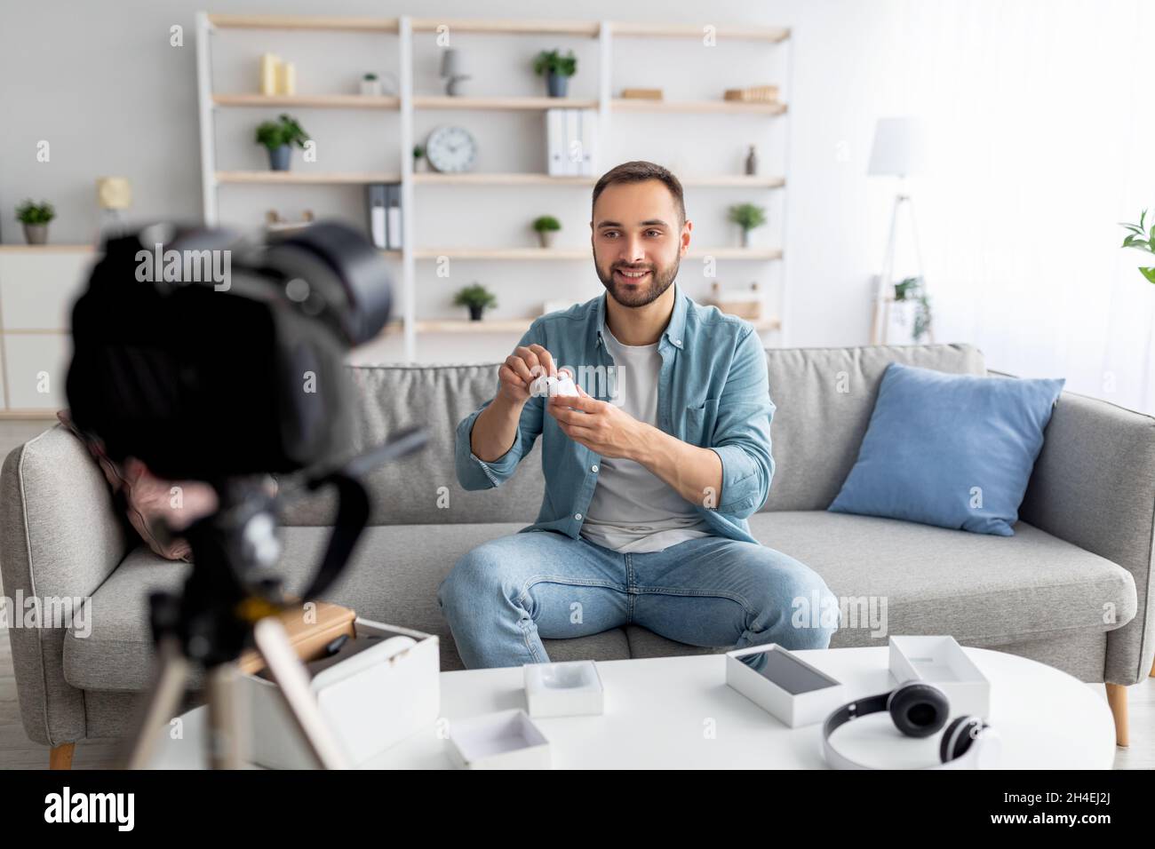 Popular male blogger shooting video review of new earhpones, using ...