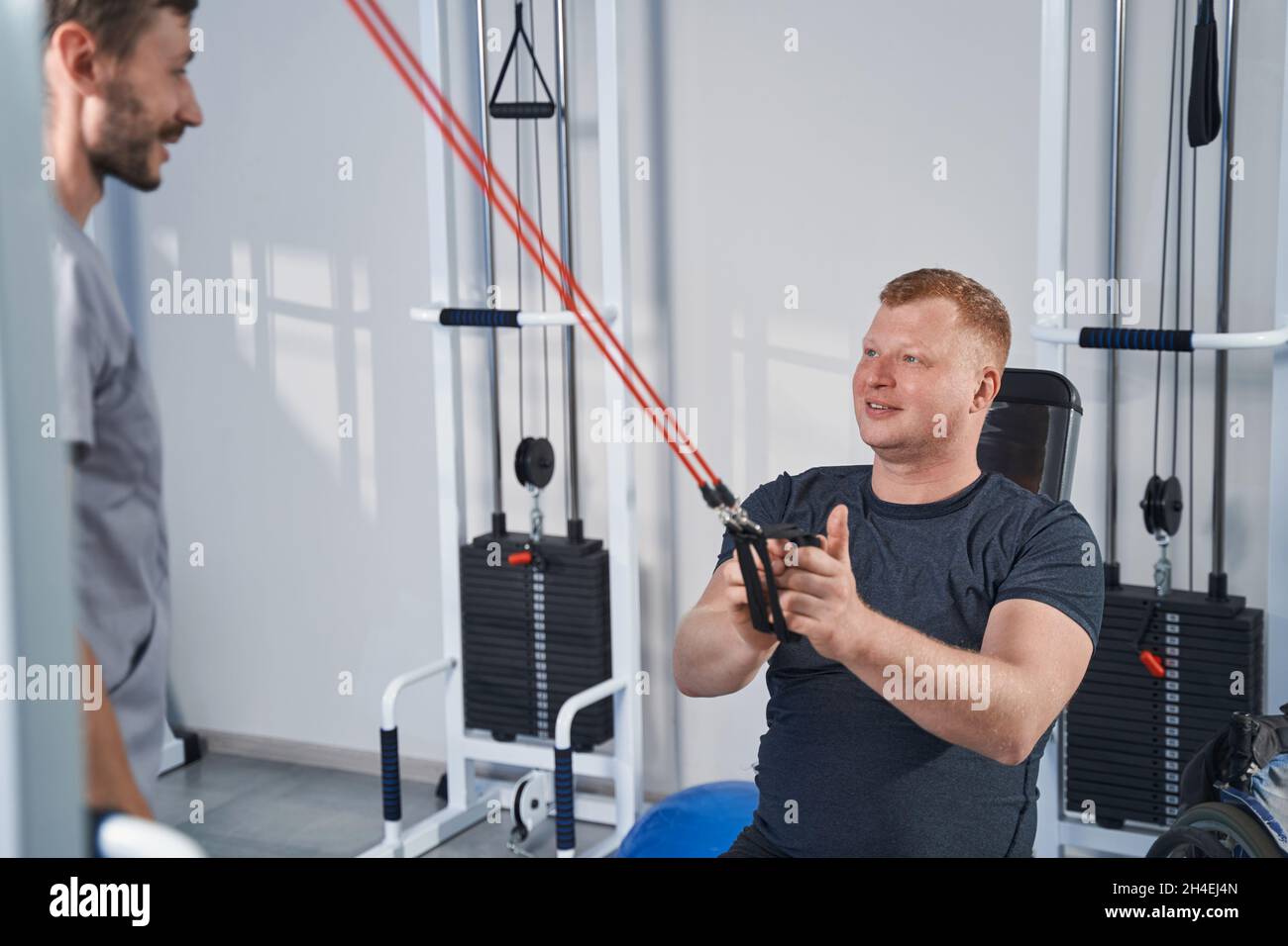 Patient pulls resistanse bands on strength-training machine Stock Photo ...