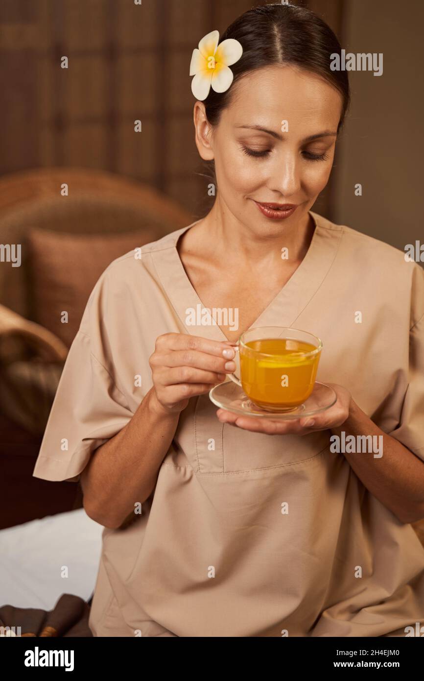 Beauty salon customer drinking herbal beverage before spa procedure ...