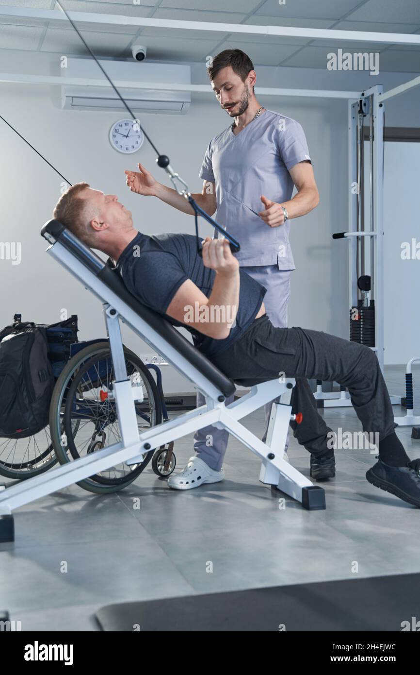Patient with injury doing strength exercises with physiotherapist help ...