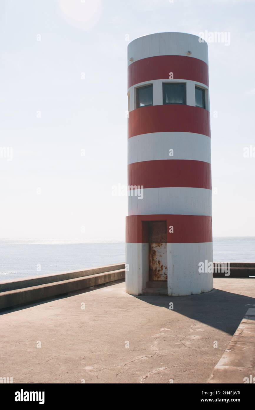 Vertical shot of a tall red white lighthouse structure on a pier Stock ...