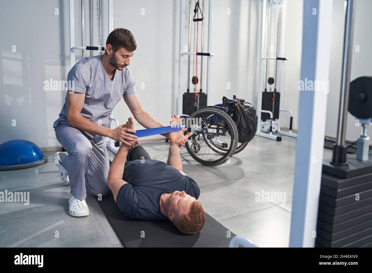 Doctor help man with disability does strength rehabilitation exercises ...