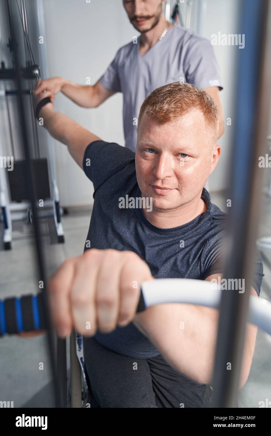 Physician helps wheelchair patient do warm-up resistance exercise Stock ...