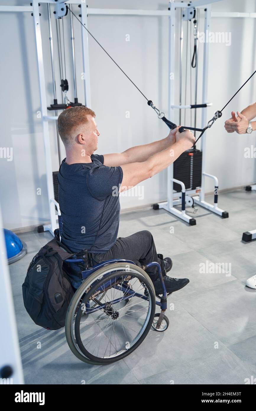 Man with disability exercises with resistance band in therapy room ...