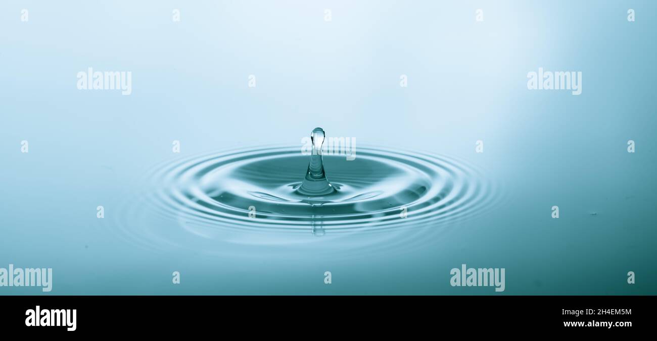 Splash of water droplets on a smooth water surface Stock Photo - Alamy