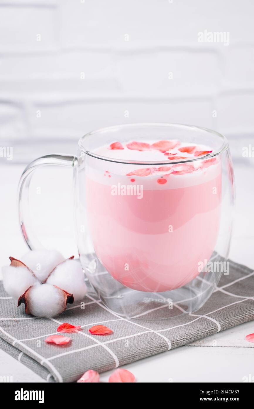 Pink matcha with rose petals on a white background. Transparent cup ...