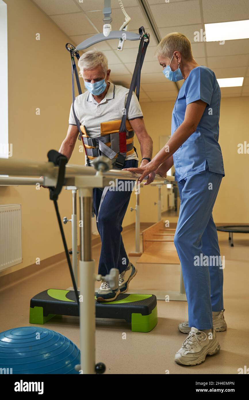 Stroke patient walks between parallel bars at rehabilitation room Stock ...