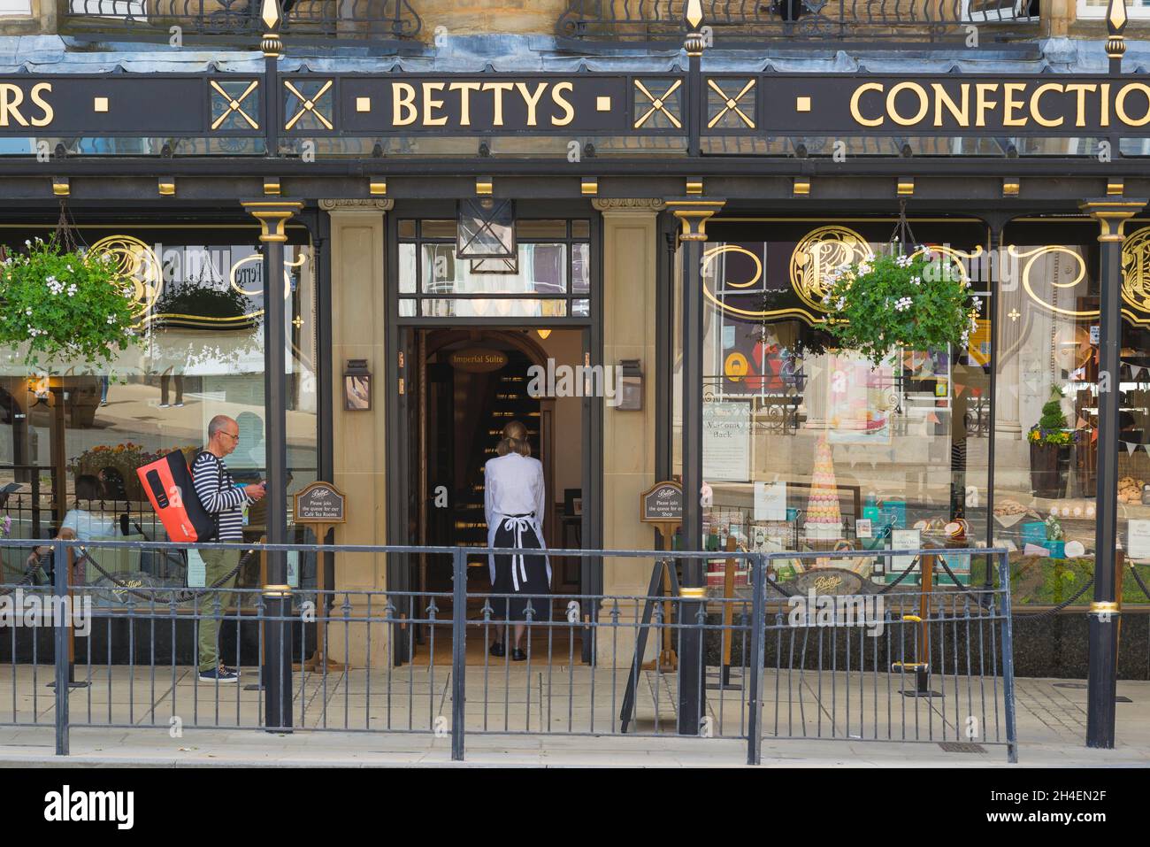 Bettys Harrogate, rear view of a waitress returning inside Bettys Cafe ...