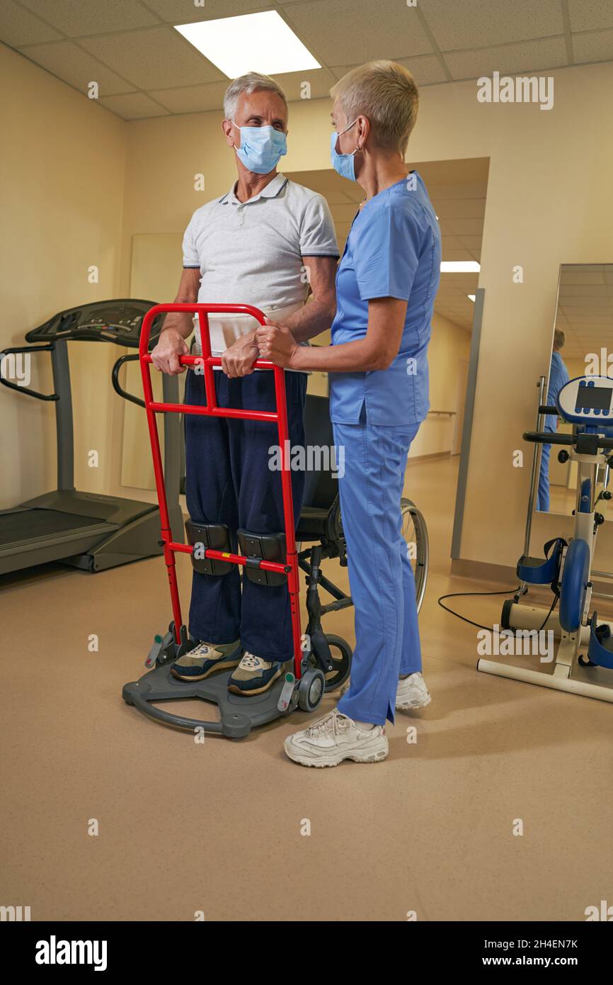 Mature man uses walking frame in medical center Stock Photo - Alamy