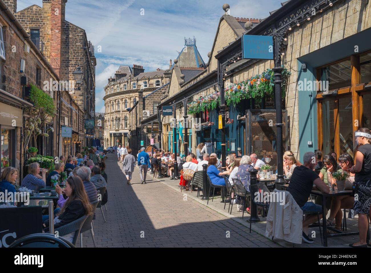 Harrogate cafe, view in summer of people relaxing outside popular bars ...