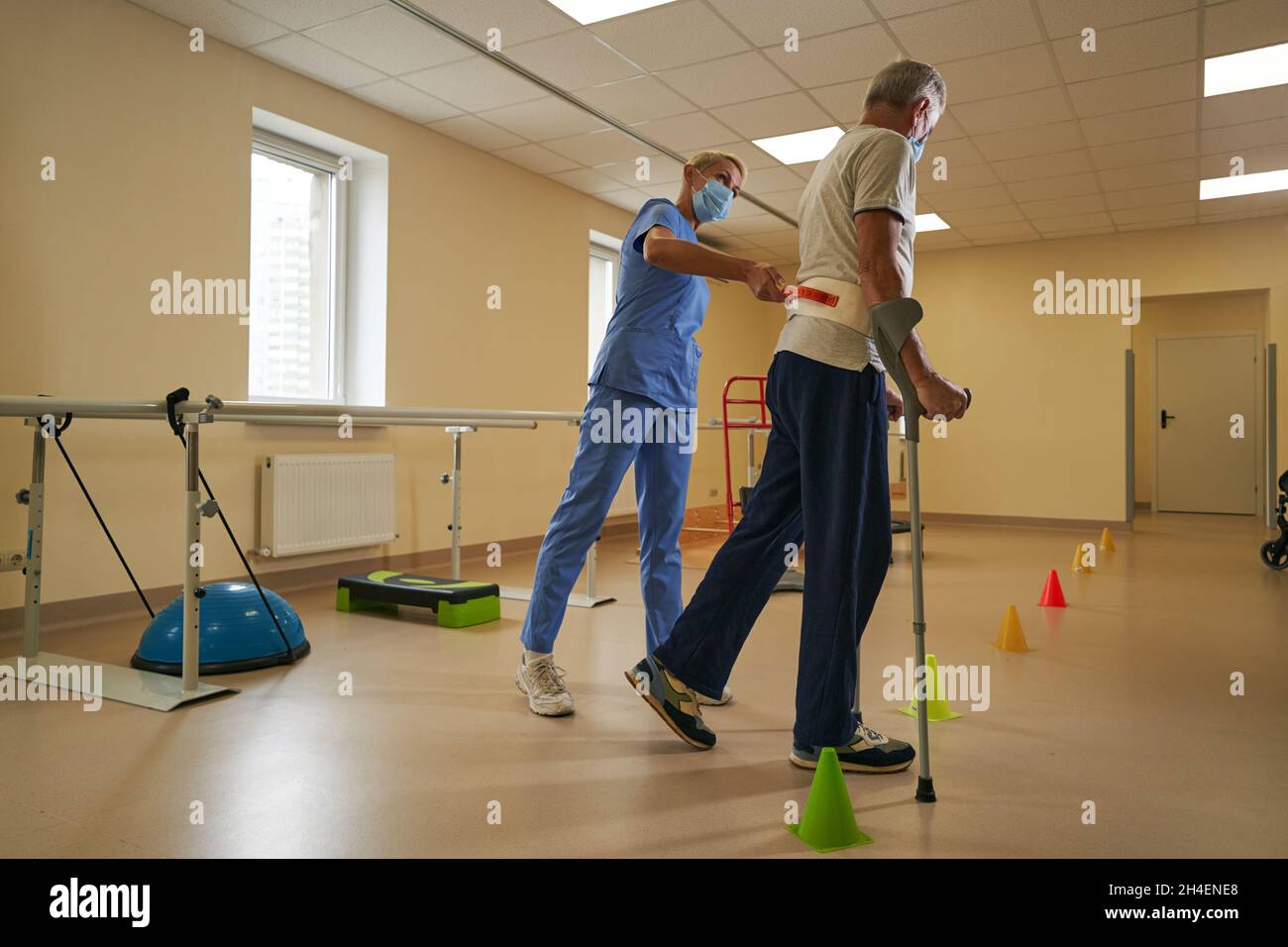 Stroke man uses crutches for support in rehab center Stock Photo - Alamy