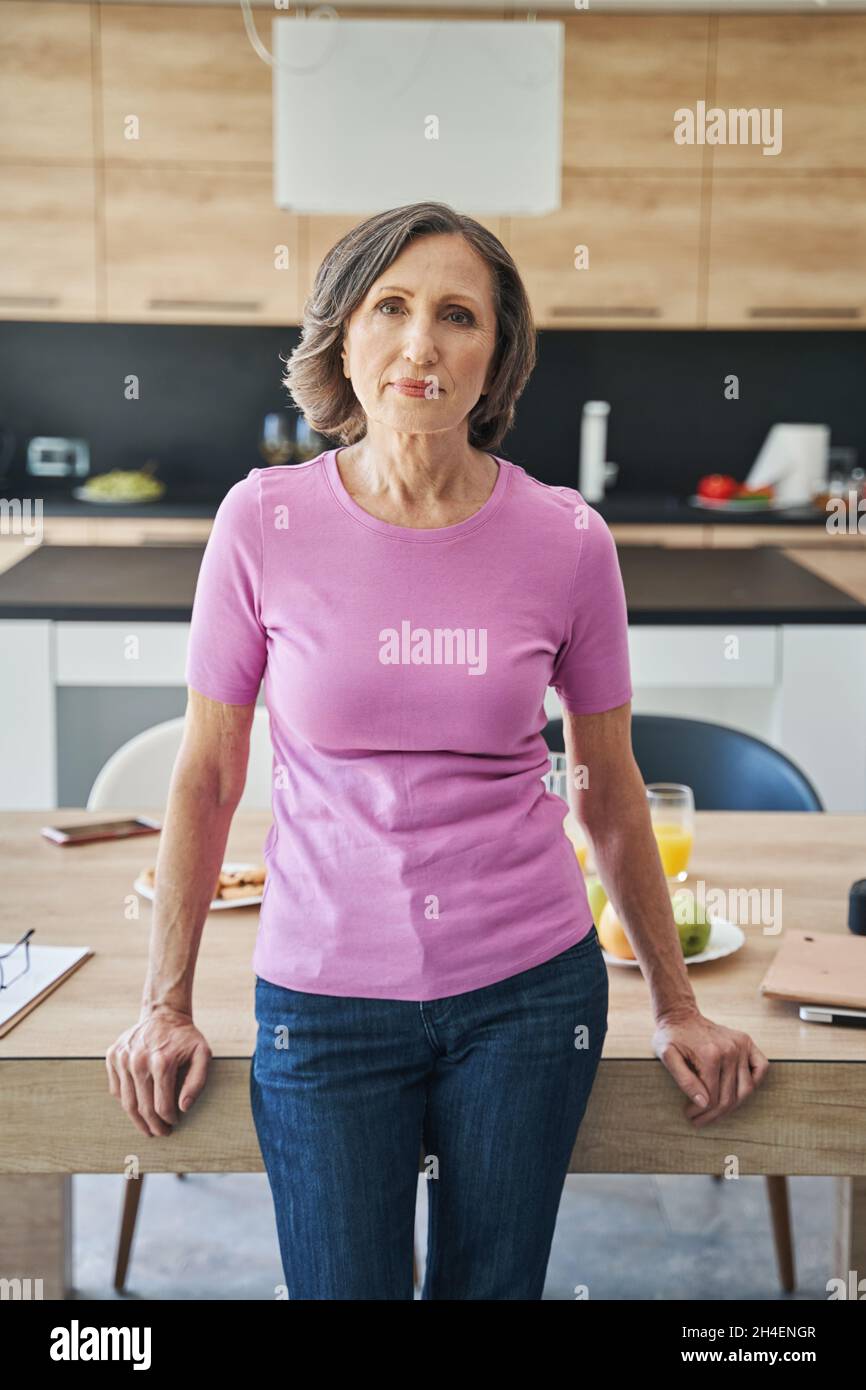 Elderly person resting against table in the kitchen Stock Photo - Alamy