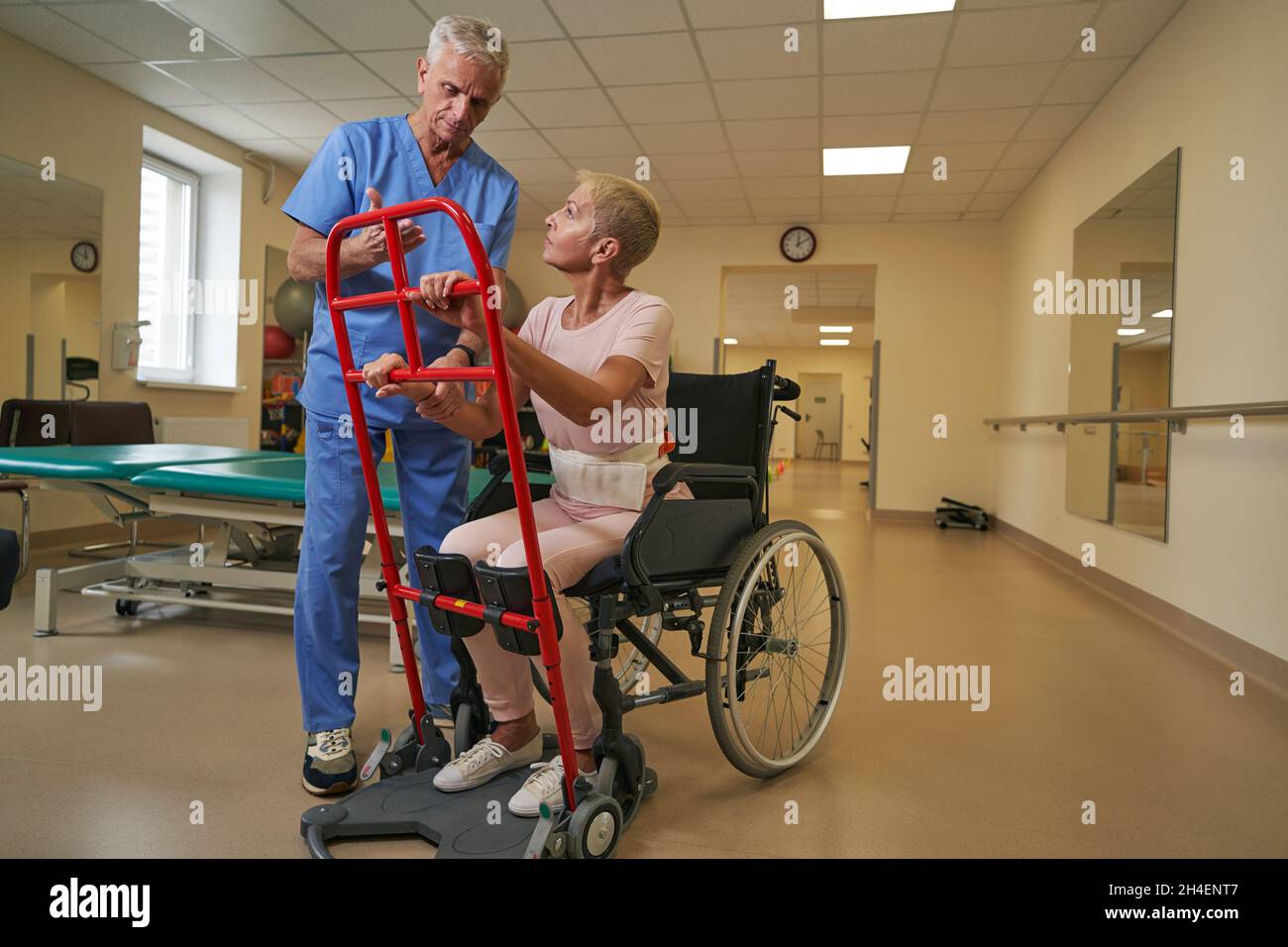 Physiotherapist teaching disabled woman to use walker at recovery ...