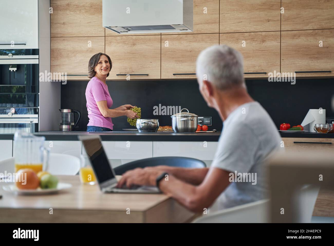 Cooking wife looking happily at her husband Stock Photo - Alamy