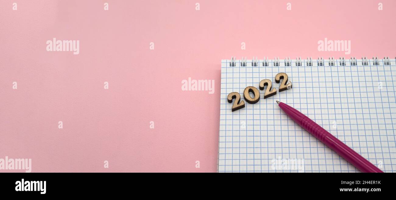 Wooden numbers 2022. Notepad on a spring. Notepad and Pen on Pink. Pink ...
