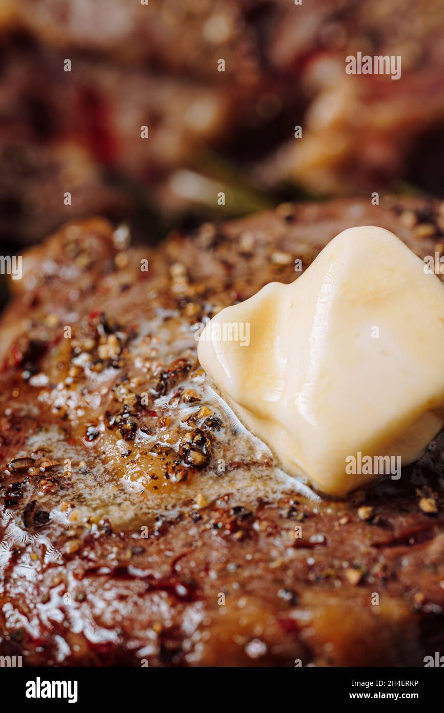 cooking sumptuous steaks in a grill pan with butter spreading over the ...