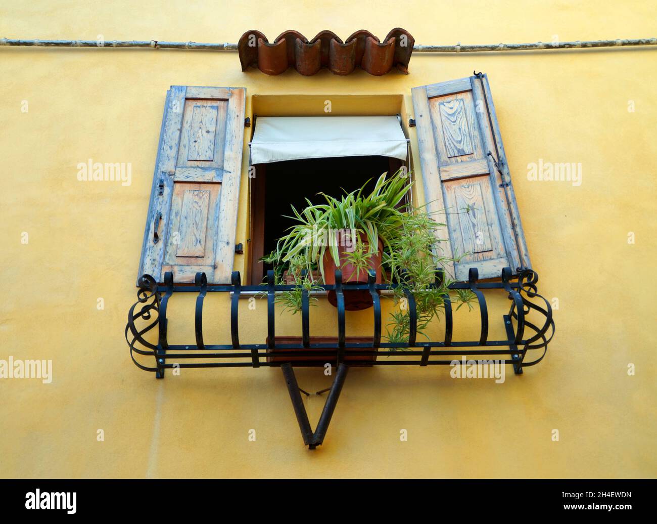 a window of the yellow house in the mediterranean town Caorle in the ...