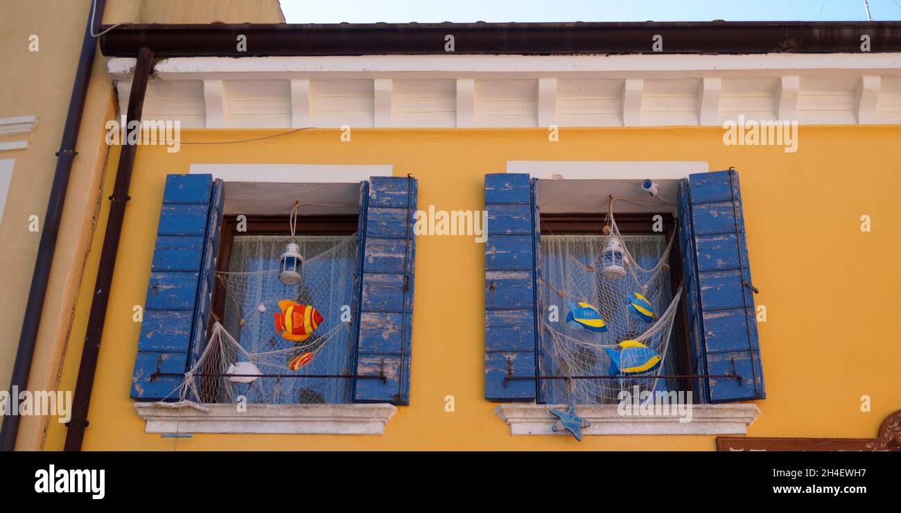 quaint windows with blue shutters in the mediterranean town of Caorle ...